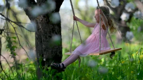 Happy cute little girl swinging on a swi... | Stock Video | Pond5