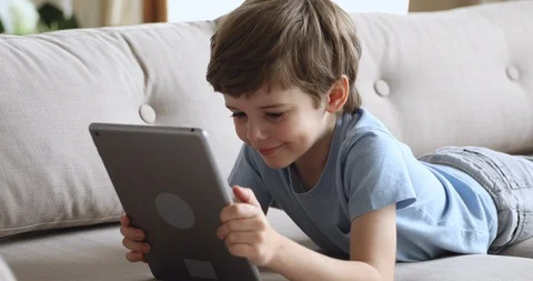 Happy cute preschool boy using tablet ly... | Stock Video | Pond5