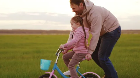 happy dad teaches little child ride two ... | Stock Video | Pond5