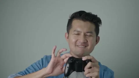 Happy face of Asian gamer holding joyst... | Stock Video | Pond5