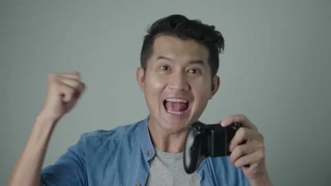 Happy face of Asian gamer holding joyst... | Stock Video | Pond5
