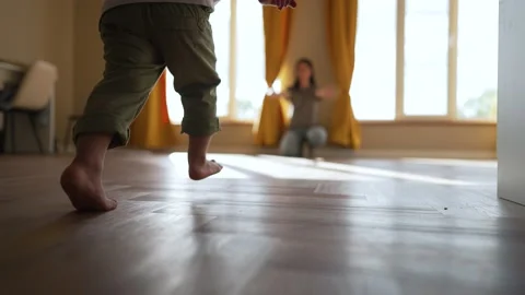 Happy family. Baby feet walk on floor to... | Stock Video | Pond5