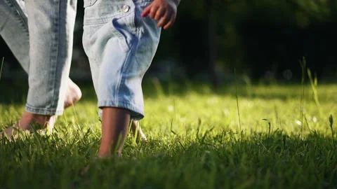 Happy family. Baby takes first steps wit... | Stock Video | Pond5
