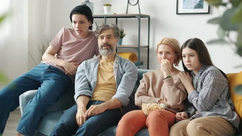 Happy family watching scary movie on TV ... | Stock Video | Pond5