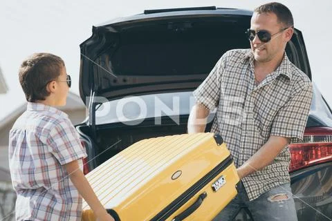 Happy father and son getting ready for road trip on a sunny day ...