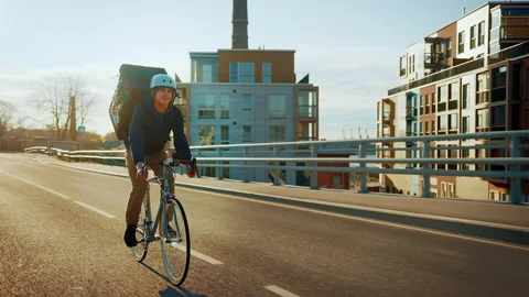 Happy Food Delivery Courier Rides a Bike... | Stock Video | Pond5