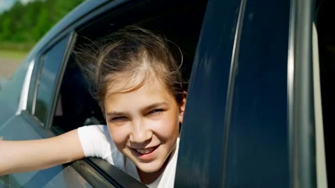 Happy girl kid child leaned out of a car... | Stock Video | Pond5