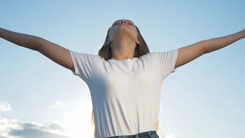 Happy girl with raised arms above her he... | Stock Video | Pond5