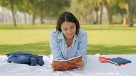 Happy Indian girl reading a book | Stock Video | Pond5