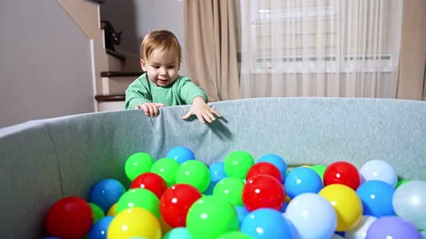 Happy kid throwing balls into the soft b... | Stock Video | Pond5