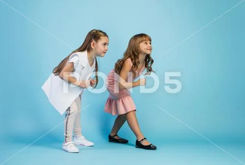 Happy kids, girls isolated on blue studio background. Look happy ...
