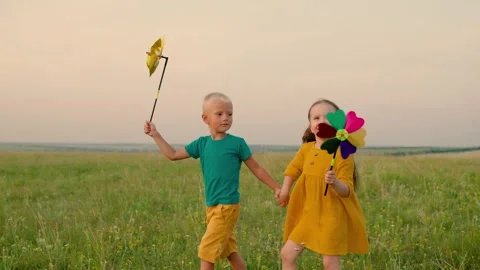 Happy kids play pinwheel in nature. Fami... | Stock Video | Pond5
