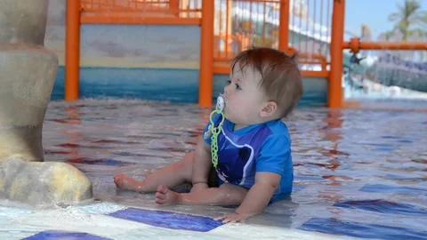 Happy little boy sitting near the swimmi... | Stock Video | Pond5