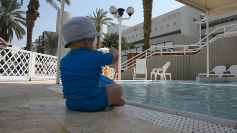 Happy little boy sitting near the swimmi... | Stock Video | Pond5