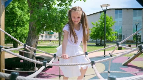 Happy Little girl climbing rope net at o... | Stock Video | Pond5