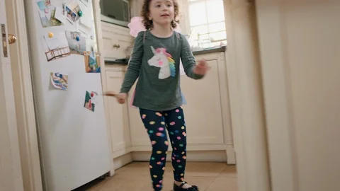 happy little girl dancing in kitchen wea... | Stock Video | Pond5