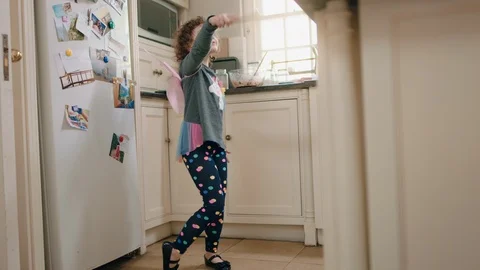 happy little girl dancing in kitchen wea... | Stock Video | Pond5