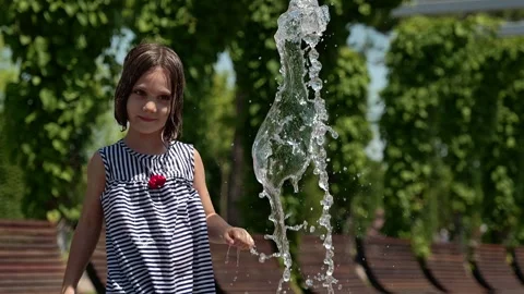 Happy little girl playing with a jet of ... | Stock Video | Pond5