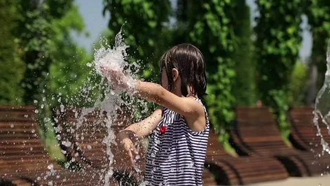 Happy little girl playing with a jet of ... | Stock Video | Pond5