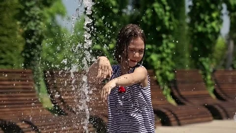 Happy little girl playing with a jet of ... | Stock Video | Pond5