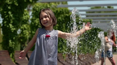 Happy little girl playing with a jet of ... | Stock Video | Pond5