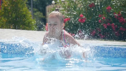 Happy little girl playing in outdoor swi... | Stock Video | Pond5
