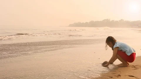 Happy little girl playing sand alone on ... | Stock Video | Pond5