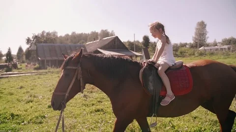 A happy little girl riding a horse in th... | Stock Video | Pond5
