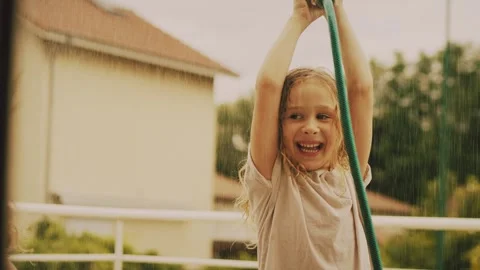Happy little girls sprinkle water with a... | Stock Video | Pond5