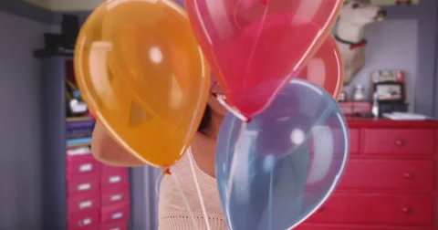 Happy Mexican girl popping balloons at h... | Stock Video | Pond5