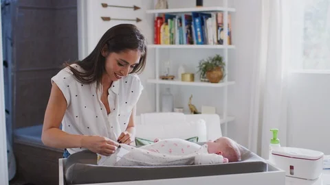 Happy mother changing the diaper of her ... | Stock Video | Pond5