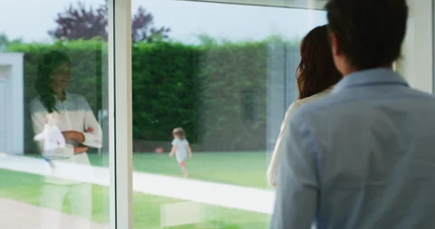 Happy parents looking through window and... | Stock Video | Pond5