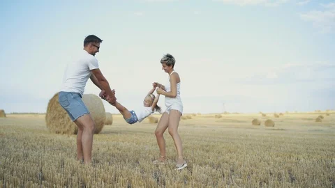 Happy parents wobble child up and kissin... | Stock Video | Pond5