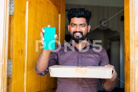 Happy smiling customer with courier box in hand showing green screen ...
