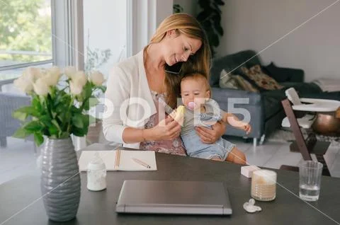 Photograph: Happy working mom hugging and playing with cute baby at ...