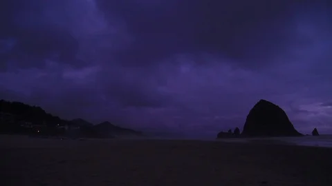 Haystack Rock with purple clouds at nigh... | Stock Video | Pond5