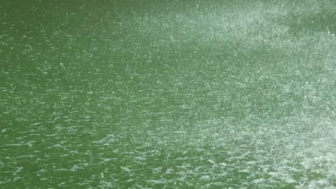 Heavy rain, drops falling on surface of ... | Stock Video | Pond5