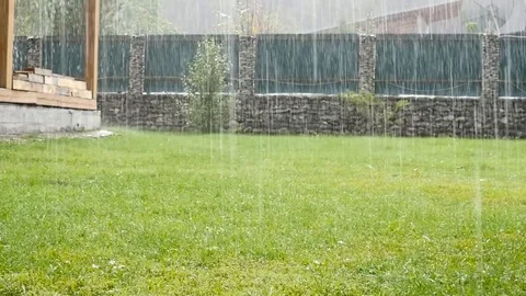 Heavy rain shower in backyard at unfinis... | Stock Video | Pond5