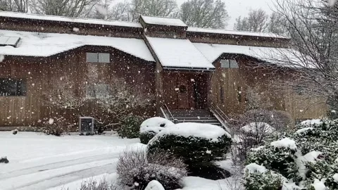 Heavy snow falling in front of big house... | Stock Video | Pond5