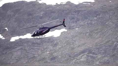 Helicopter flying between mountains | Stock Video | Pond5