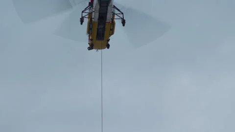 Helicopter lifts cargo on cable. Rope is... | Stock Video | Pond5
