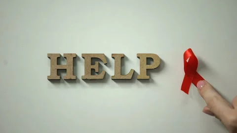 Help word and red ribbon on table, AIDS ... | Stock Video | Pond5