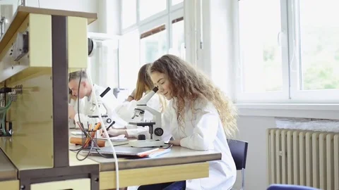 High school students with microscopes in... | Stock Video | Pond5