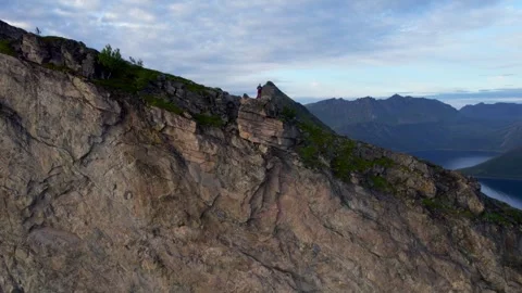 Hiker standing on the edge of a steep cl... | Stock Video | Pond5