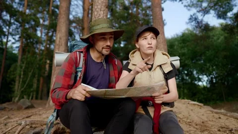 Hikers learning paper route map while tr... | Stock Video | Pond5