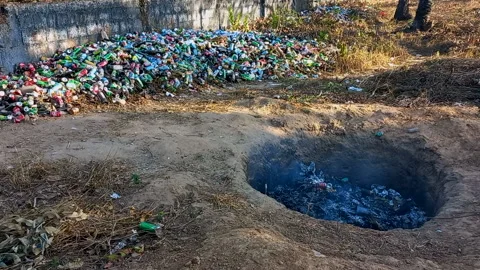 Hole in the earth burning garbage, bottl... | Stock Video | Pond5