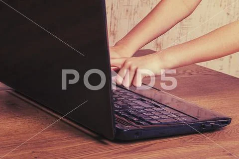 Home environment. table. there is a laptop on it. the child types and ...