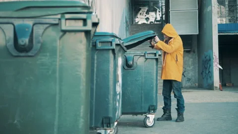 A homeless man is rummaging in the waste... | Stock Video | Pond5