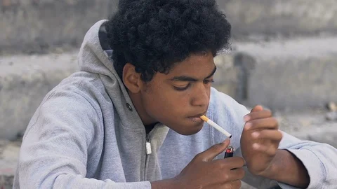 Homeless melancholic teen lighting cigar... | Stock Video | Pond5