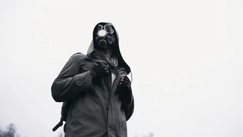 Hooded wandering man in gas mask standin... | Stock Video | Pond5